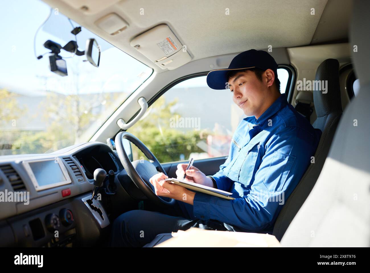 Japanese delivery man sitting in the driver seat Stock Photo - Alamy