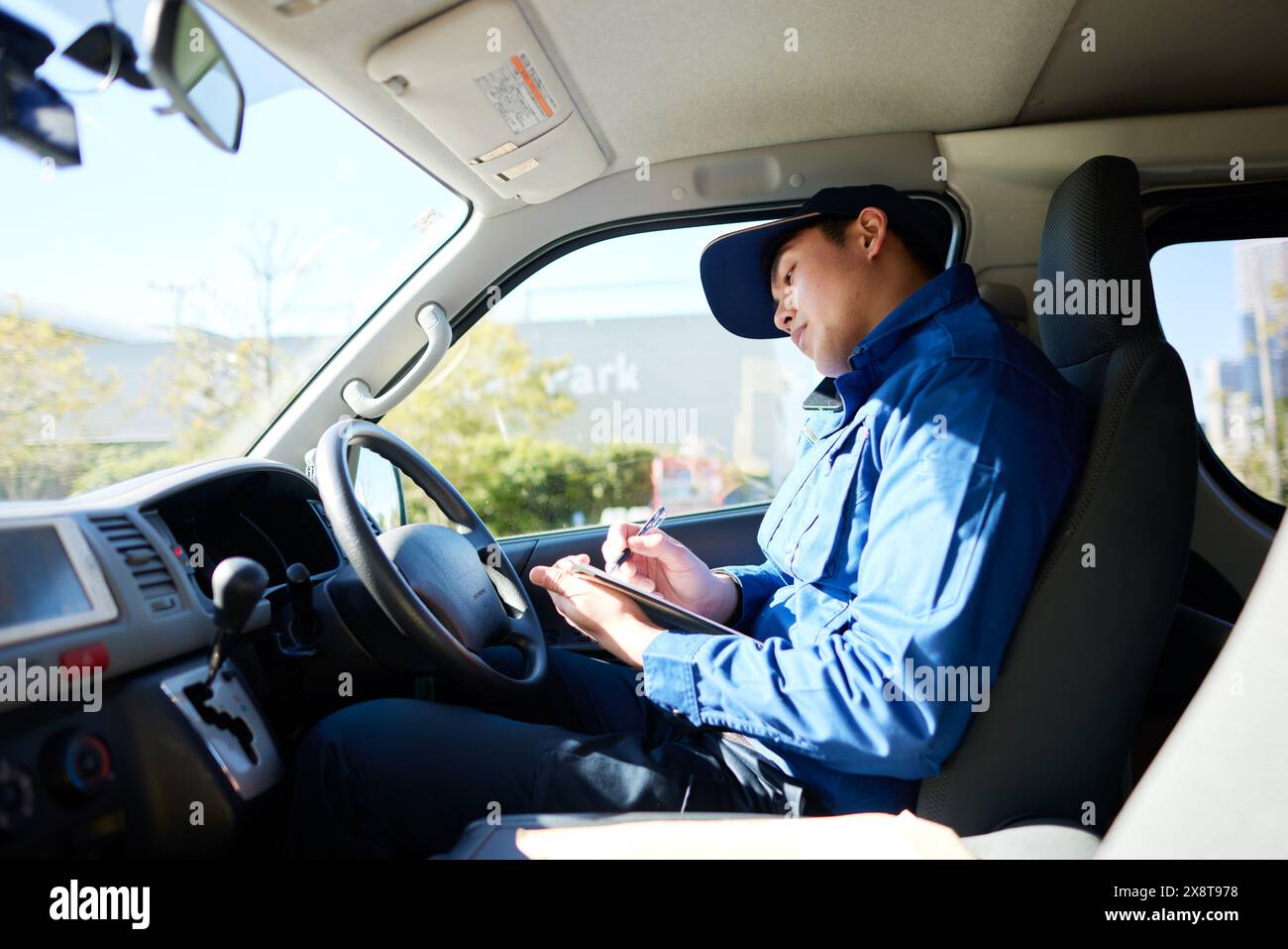 Japanese delivery man sitting in the driver seat Stock Photo - Alamy