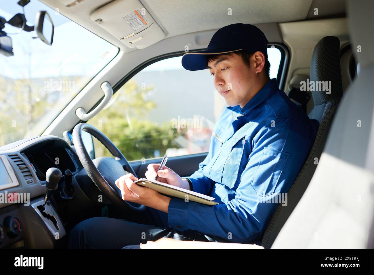 Japanese delivery man sitting in the driver seat Stock Photo - Alamy