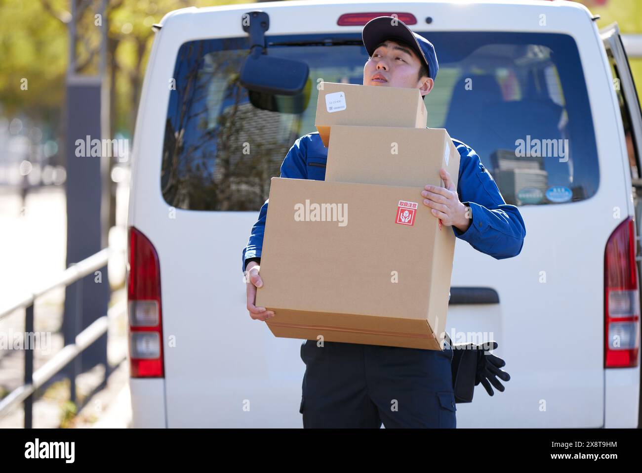Japanese delivery man standing in front of a van with boxes Stock Photo ...