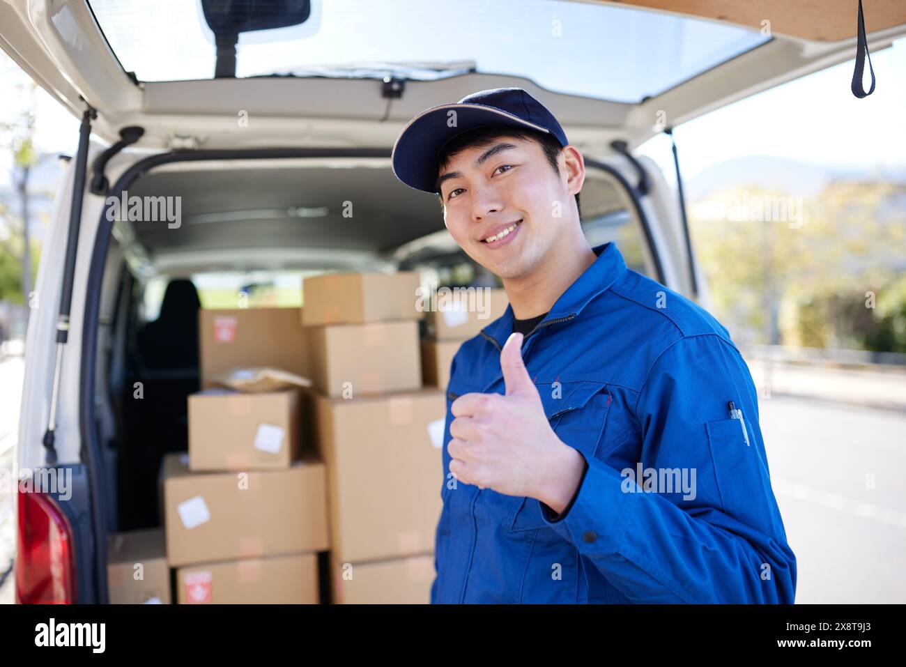 Japanese delivery man standing in front of a van with boxes Stock Photo ...