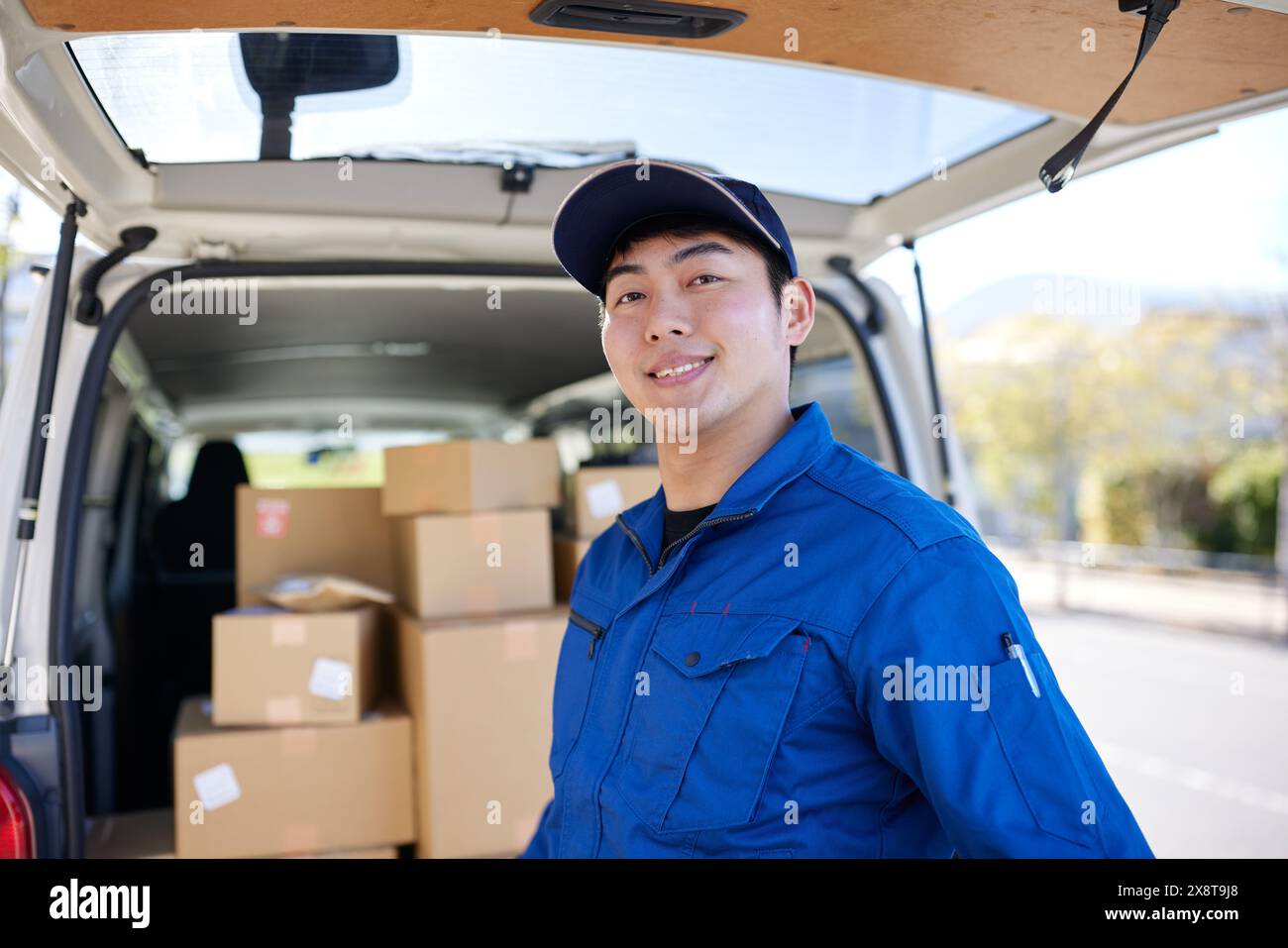Japanese delivery man standing in front of a van with boxes Stock Photo ...