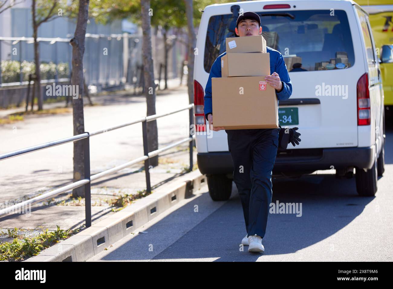 Japanese delivery man delivering boxes Stock Photo - Alamy