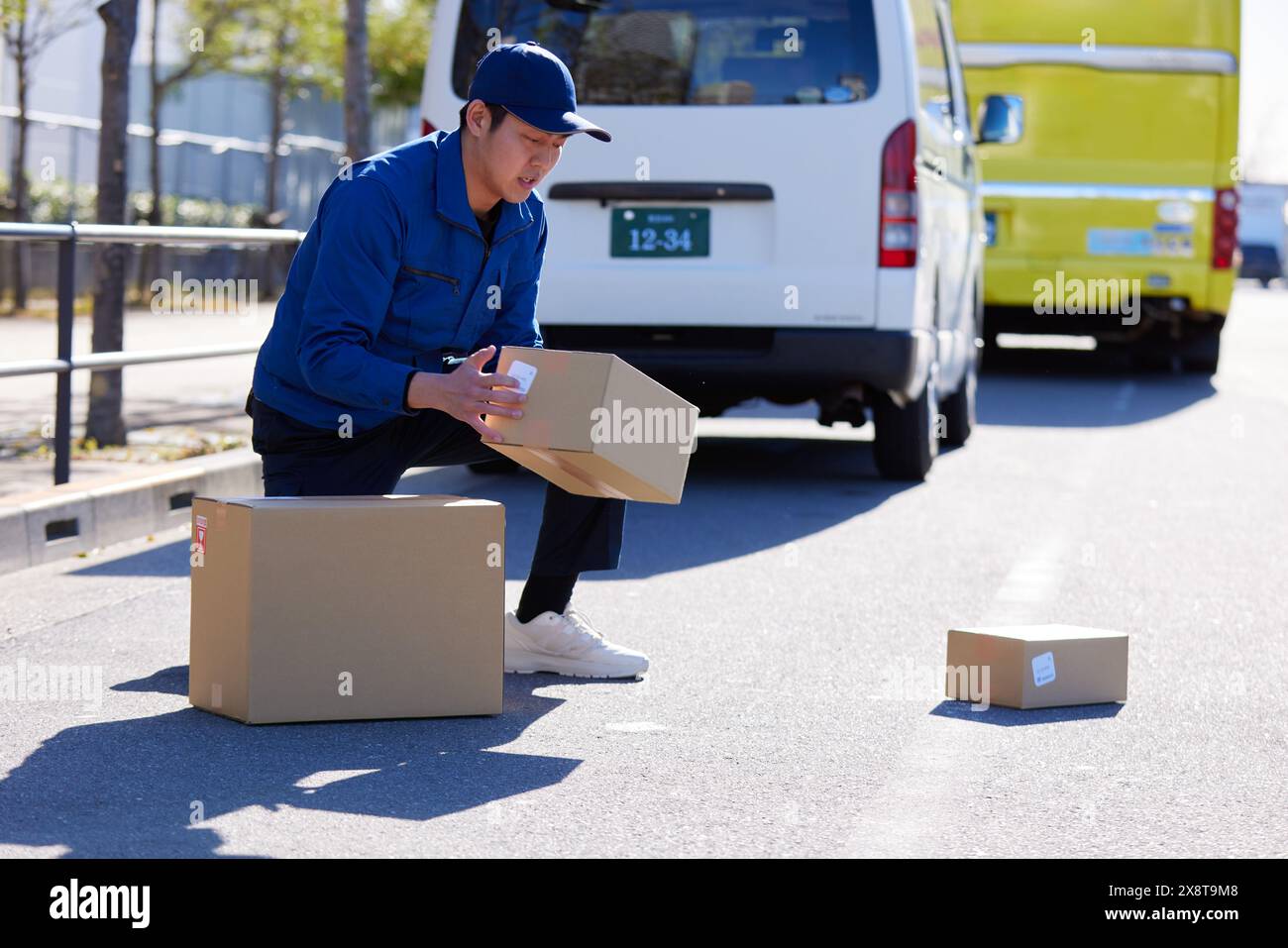 Japanese delivery man dropping boxes Stock Photo - Alamy