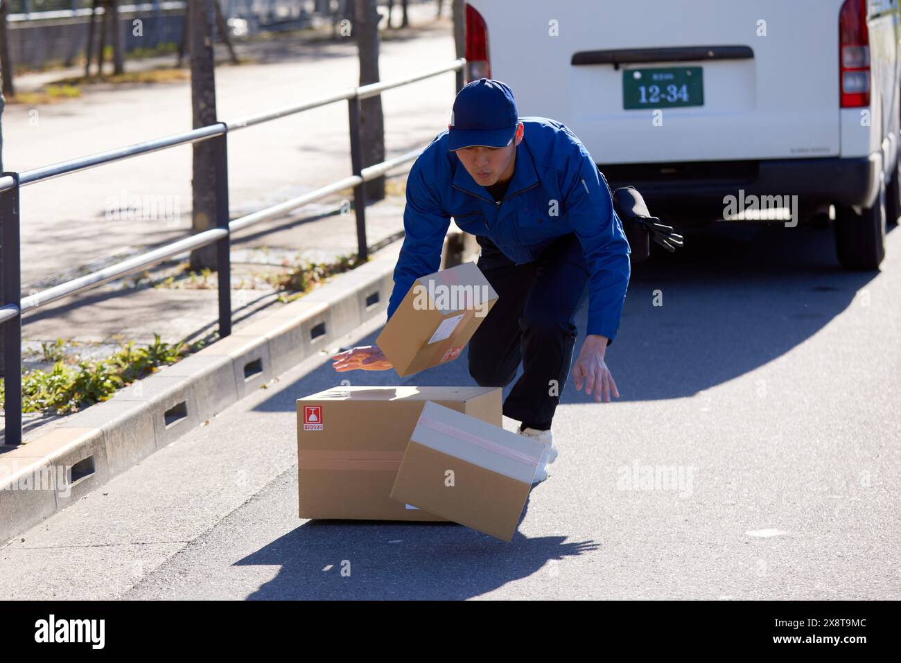 Japanese delivery man dropping boxes Stock Photo - Alamy