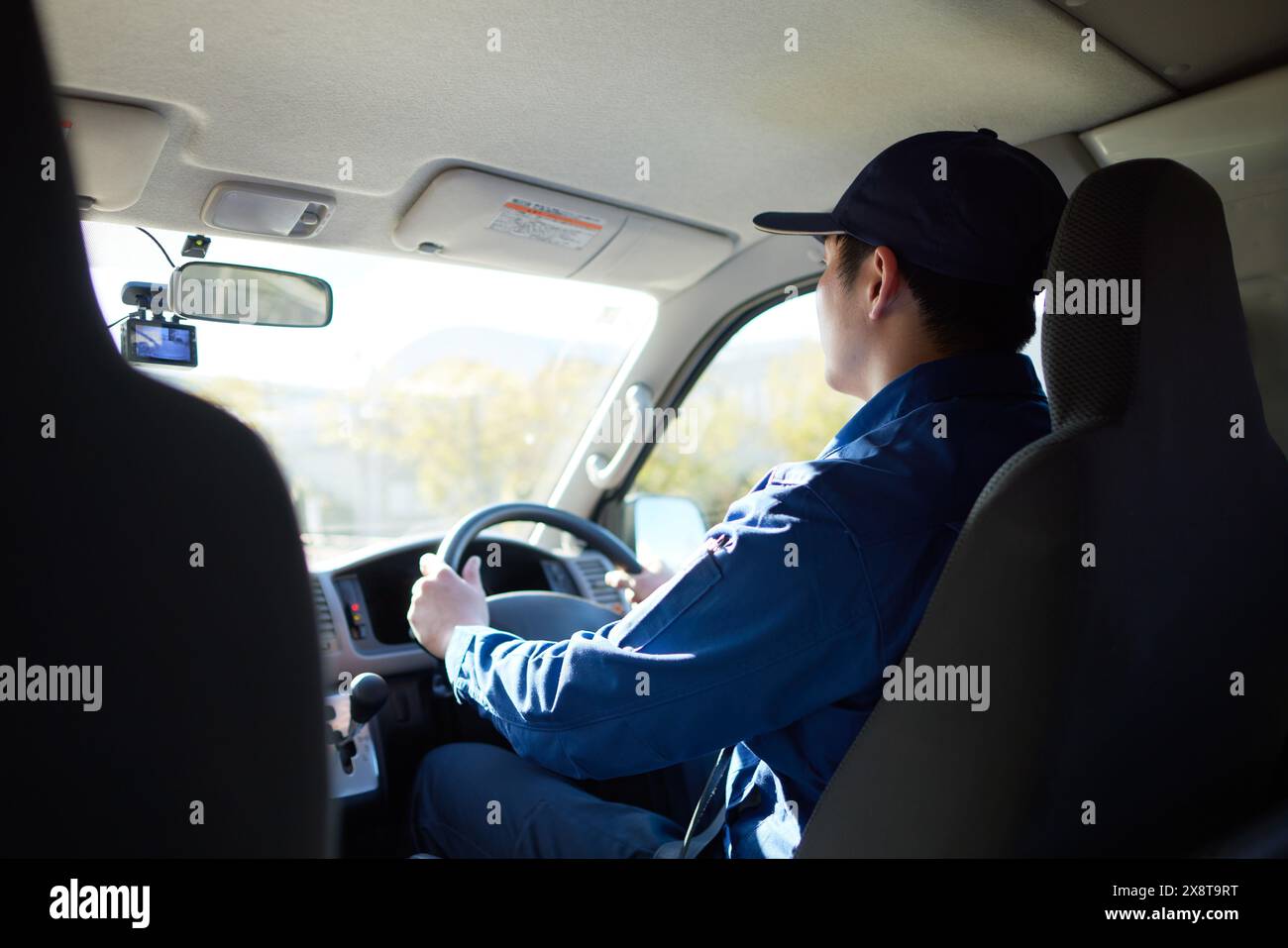 Japanese delivery man sitting in the driver seat Stock Photo - Alamy
