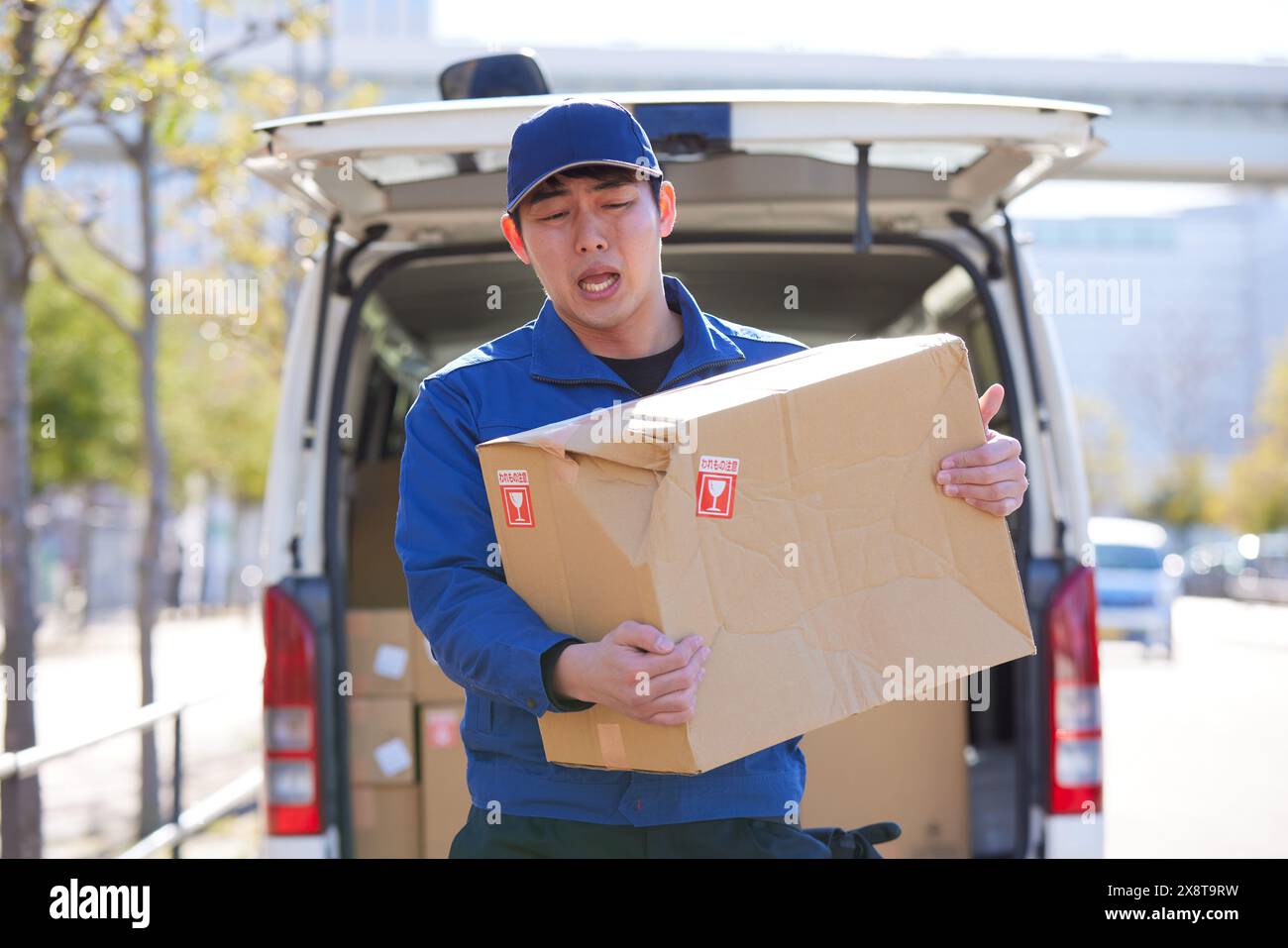 Japanese delivery man standing in front of a van with boxes Stock Photo ...