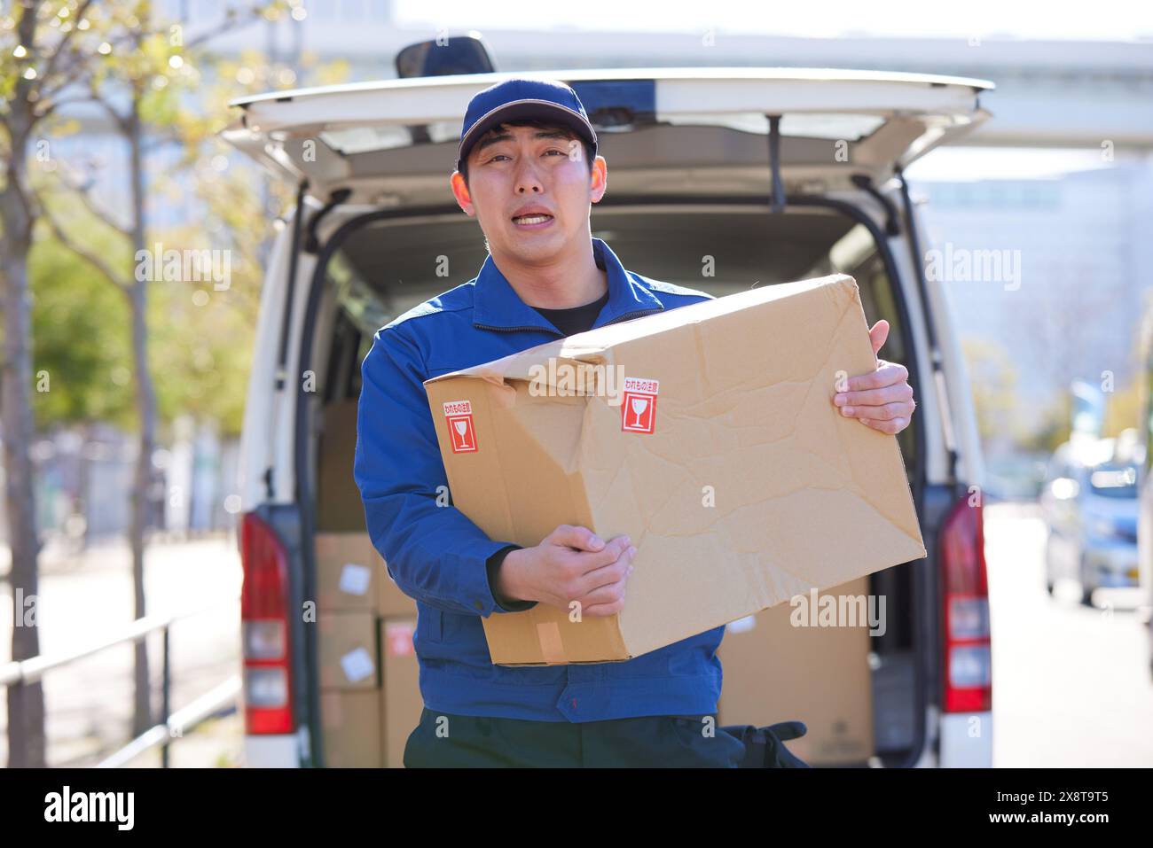 Japanese delivery man standing in front of a van with boxes Stock Photo ...