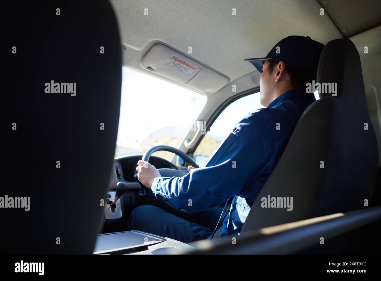 Japanese delivery man sitting in the driver seat Stock Photo - Alamy