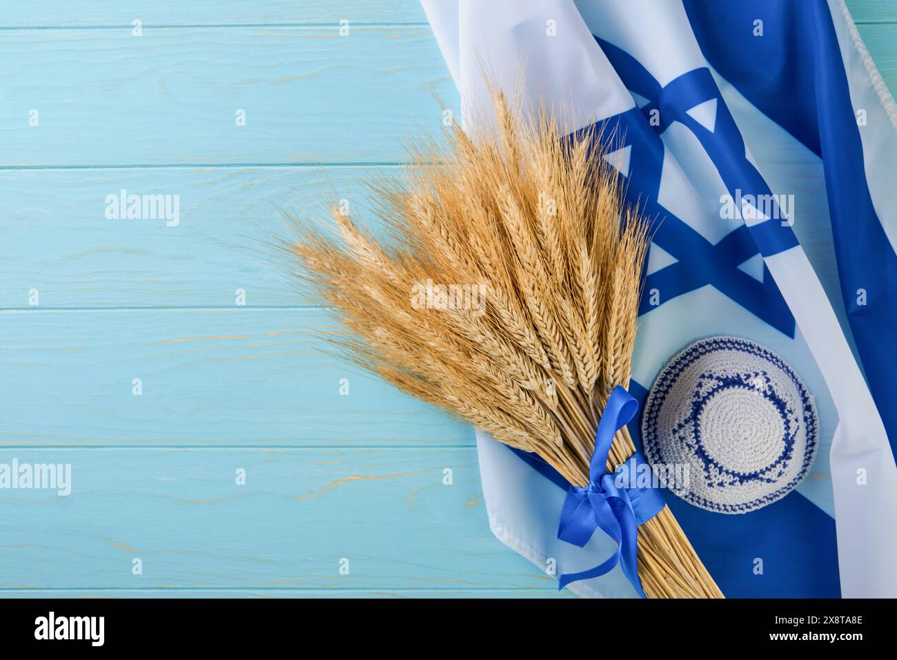 Shavuot jewish background. Ripe bouquet of wheat with blue ribbon with ...