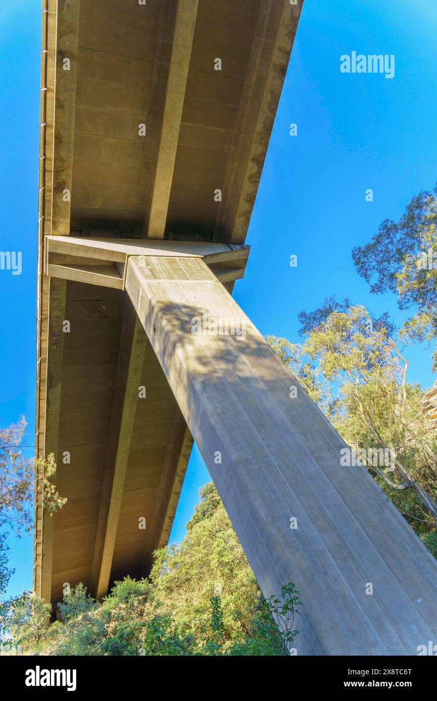 Column of a concrete viaduct seen from below with a blue sky in the ...