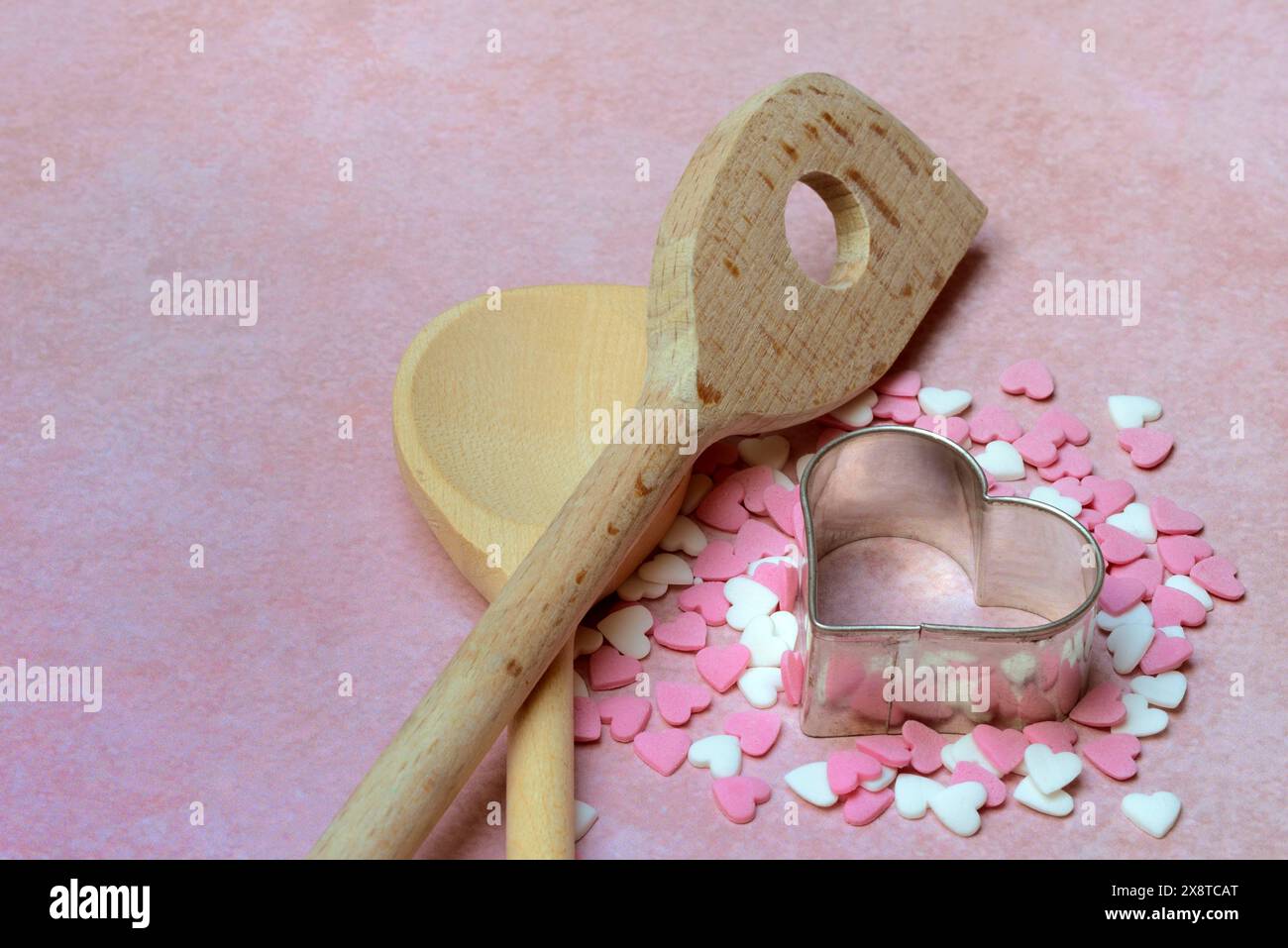Cooking spoon and heart-shaped cookie cutter with sugar hearts Stock ...