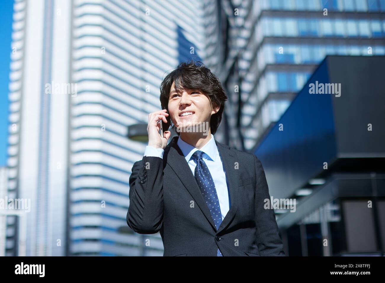 Japanese man in a suit and tie talking on a cell phone Stock Photo - Alamy