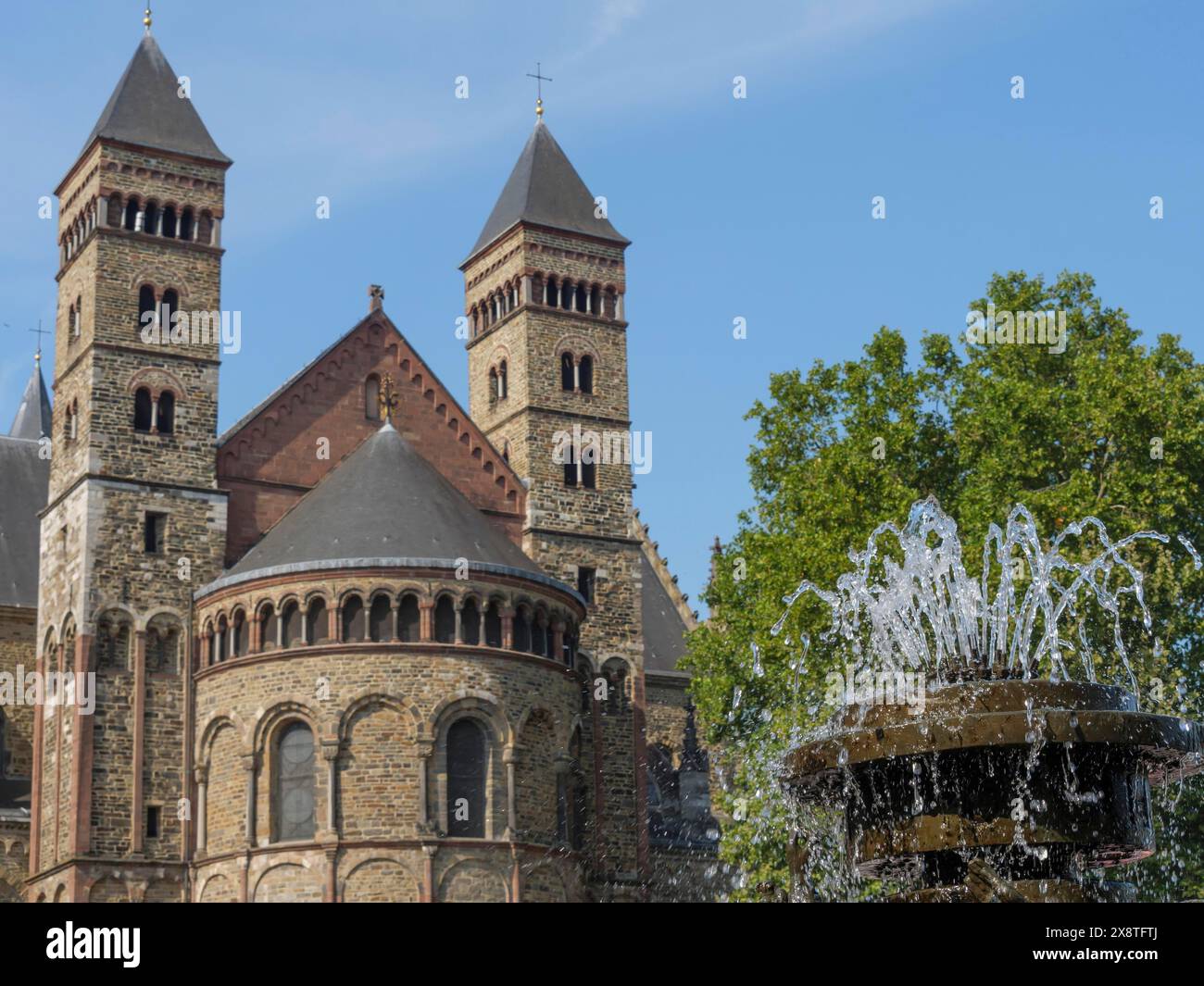 Historic church with two towers and a fountain in the foreground in ...