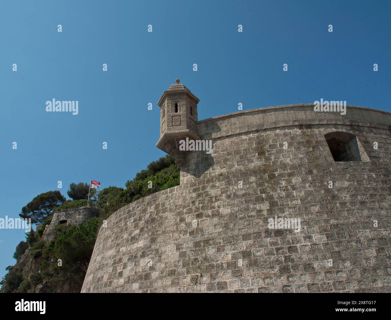 A massive section of an old stone fortress with a prominent tower under ...