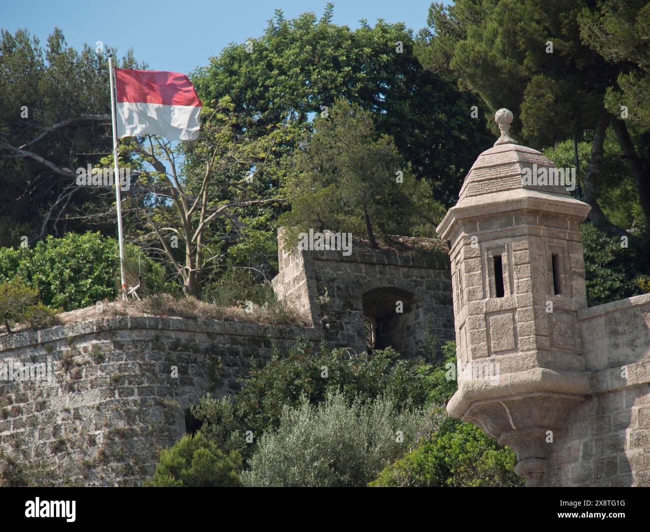 A section of an old fortress wall with a tower and a flag, surrounded ...