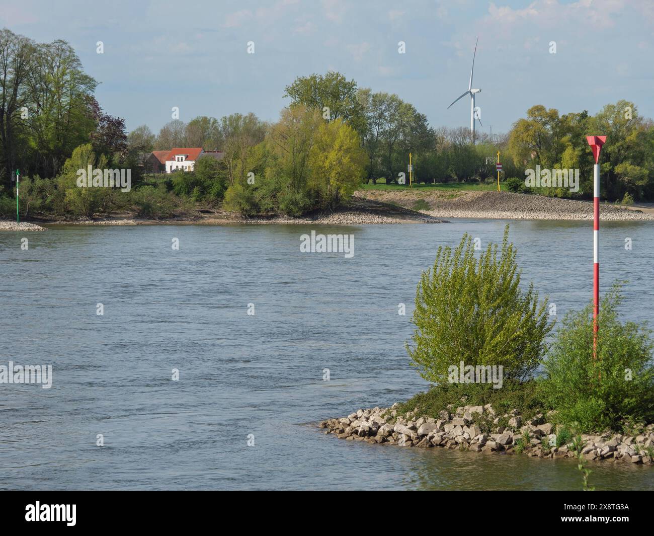 Nature view with a river, trees and a windmill in the background, old ...