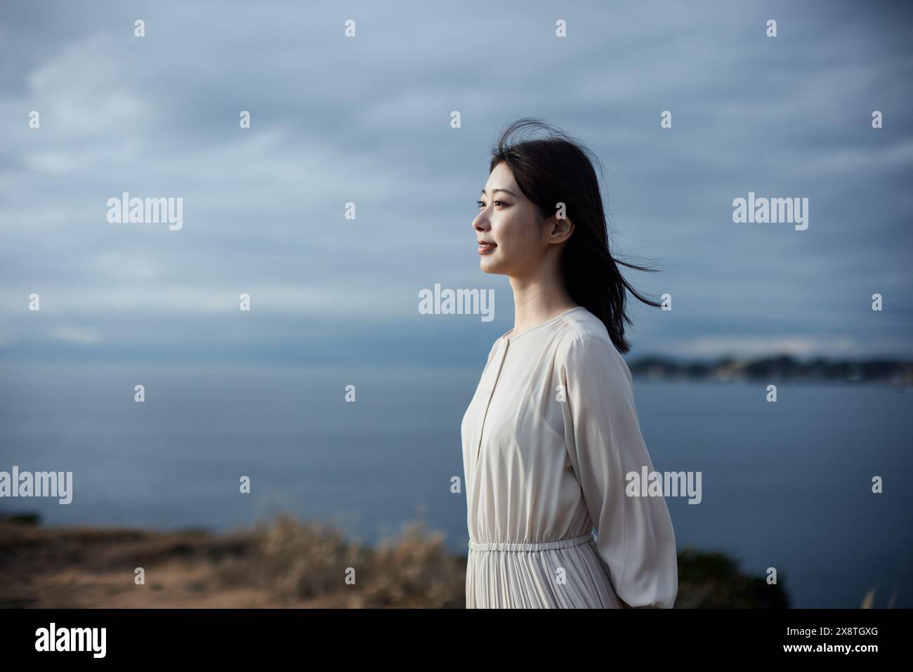 Japanese woman in a white dress looking off into the distance Stock ...