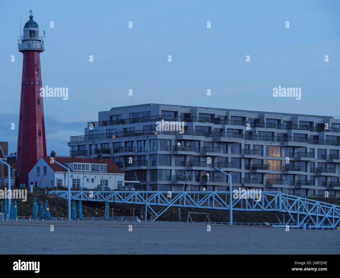 The beach with a red lighthouse and modern residential buildings at ...