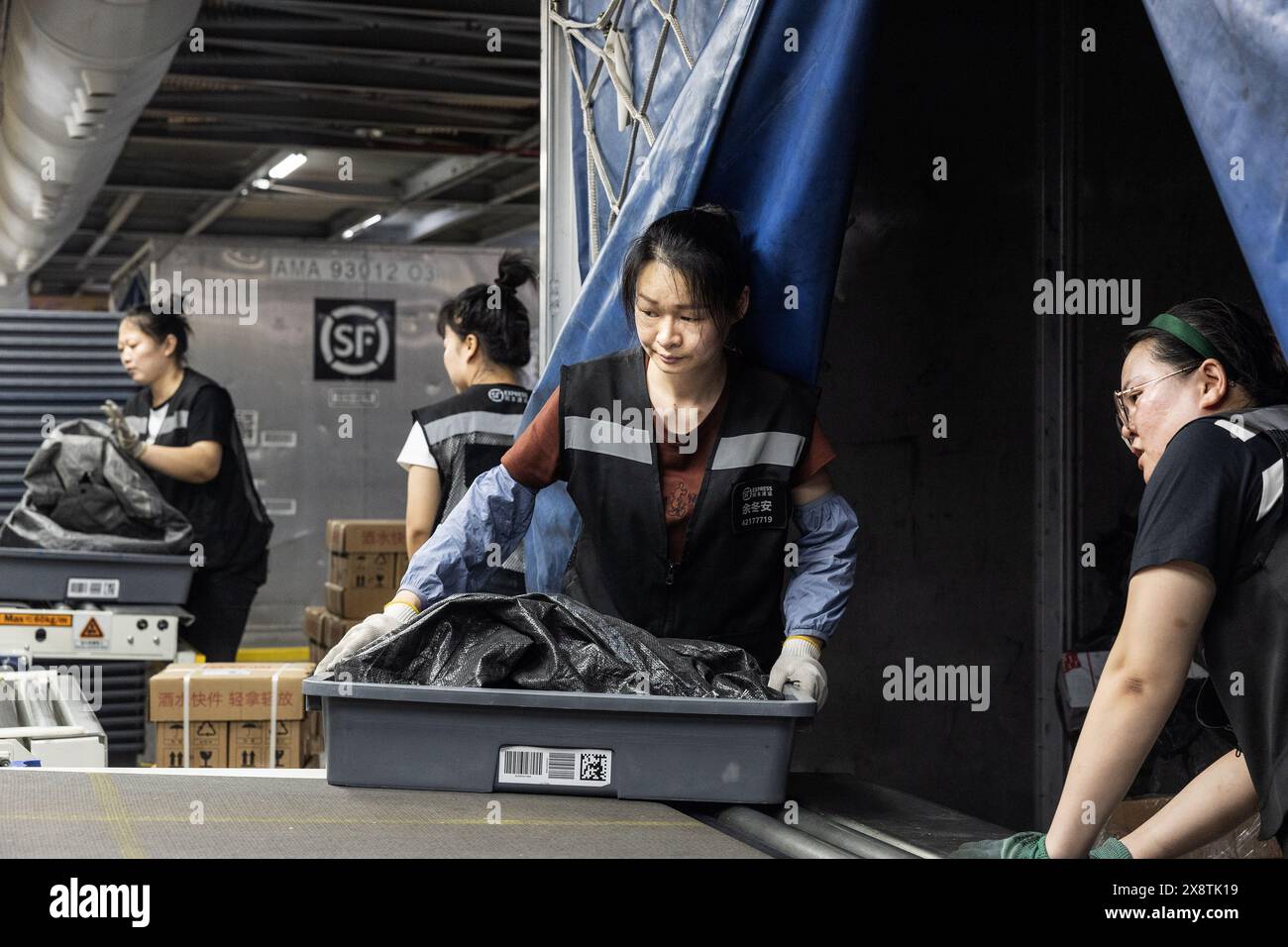 Staff members of SF airlines sort parcels at the SF transfer center of ...