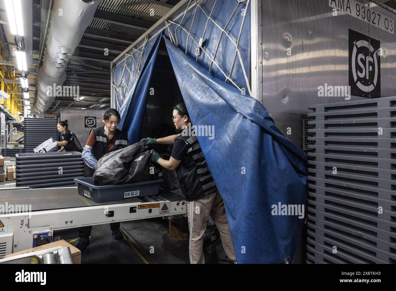 Staff members of SF airlines sort parcels at the SF transfer center of ...