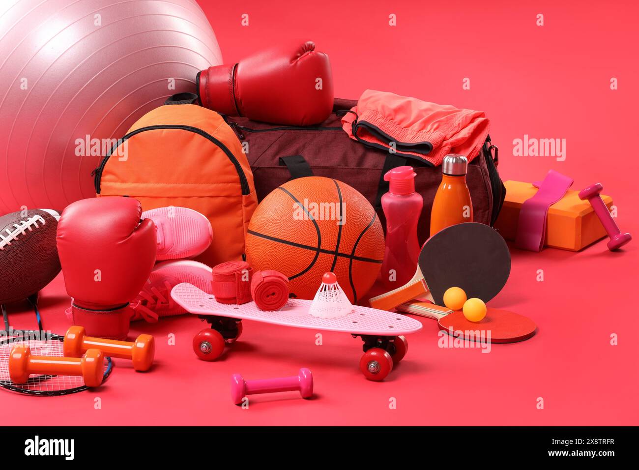 Many different sports equipment on red background Stock Photo - Alamy