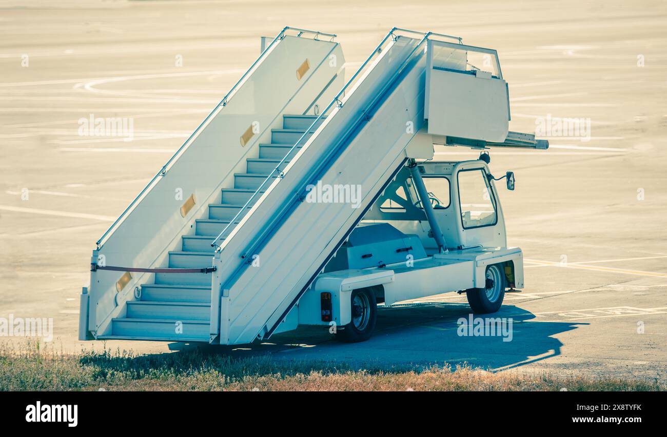 White car with stairs for passenger plane entering on the airport ...