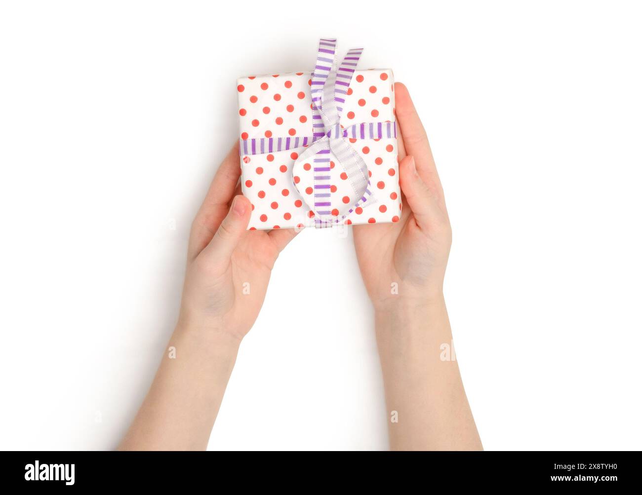Little girl's hands holding small present isolated on a white ...