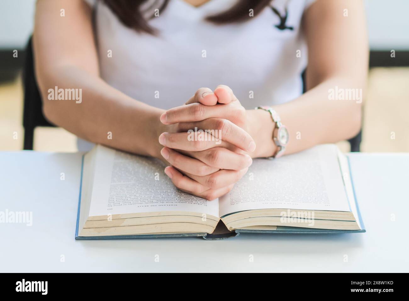 young woman clasped her hands together in prayer asking for forgiveness ...