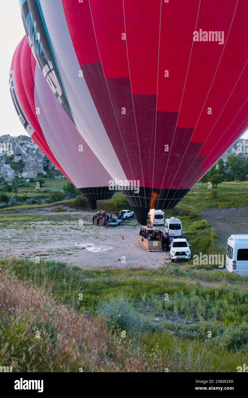 A striking hot air balloon glides above the rugged terrain of ...