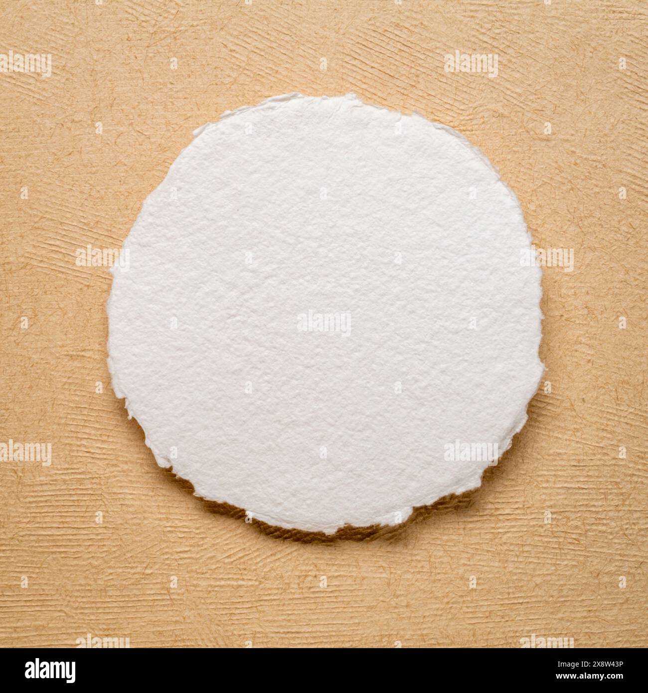 circular sheet of blank white watercolor paper against handmade amate ...