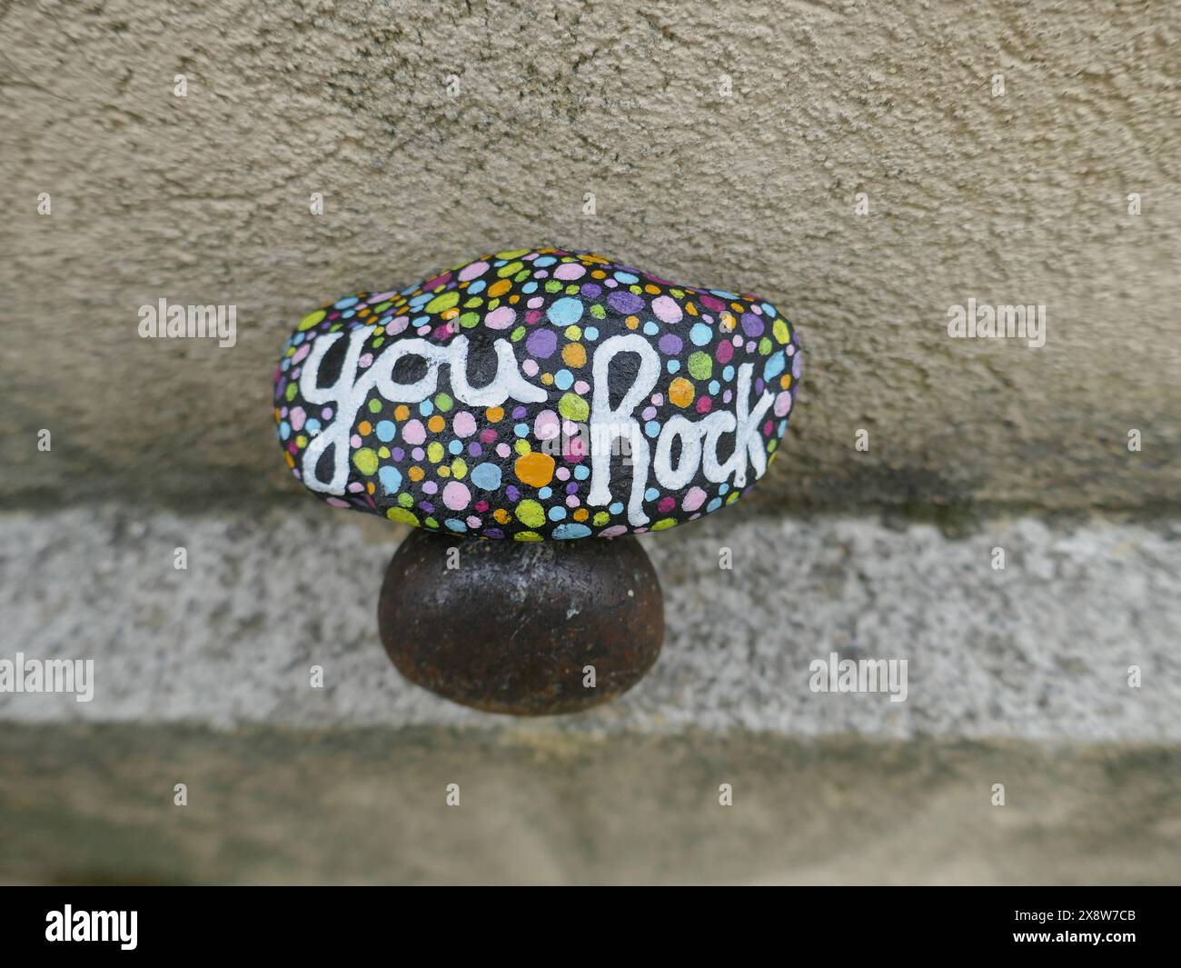 You rock kindness rock balanced on metal pin Stock Photo - Alamy
