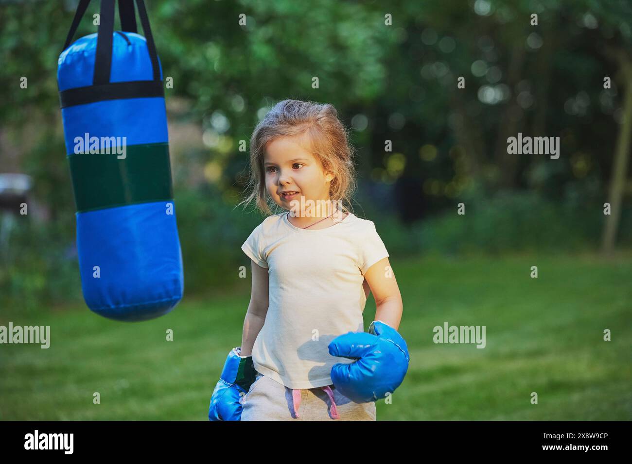 Charming child doing boxing in the backyard on the Sunset Stock Photo ...