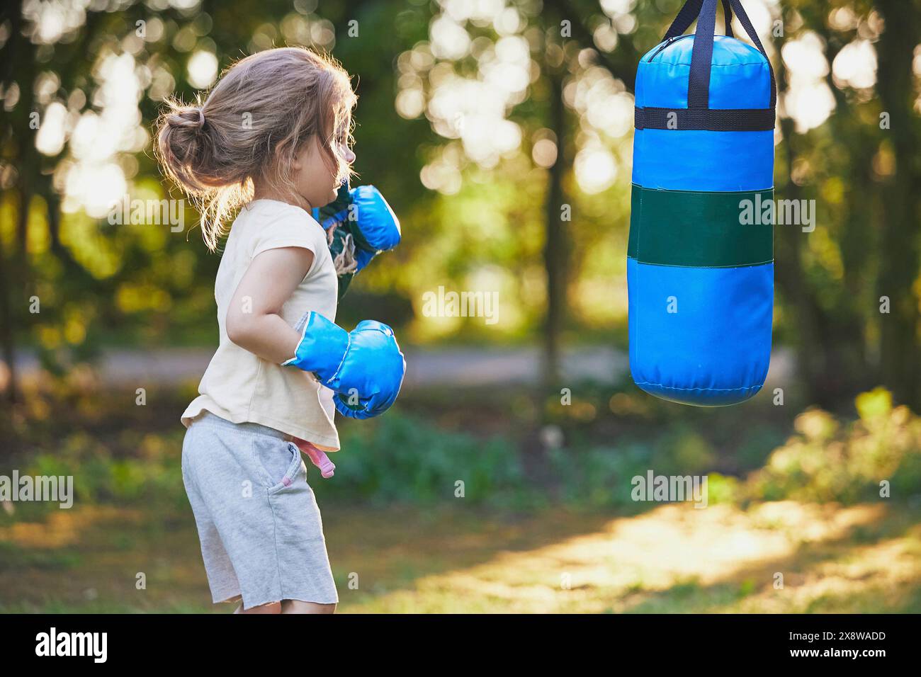 Charming child doing boxing in the backyard on the Sunset Stock Photo ...