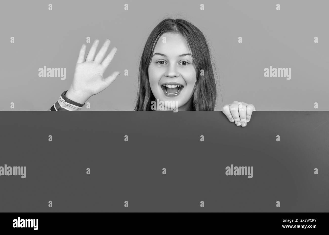 happy child behind blank blue paper with copy space for advertisement ...