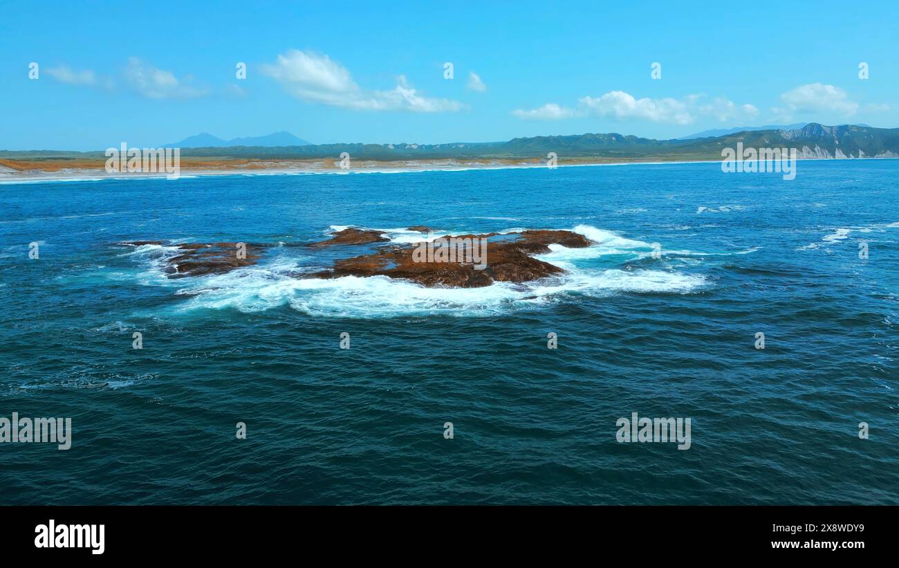 Aerial picturesque seascape with blue water, boulders rising up above ...