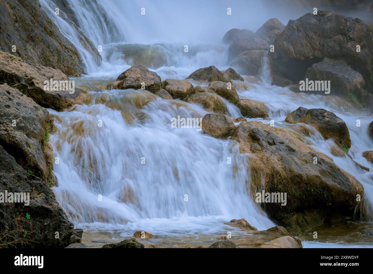 The image captures a close-up of water flowing over large rocks Stock ...