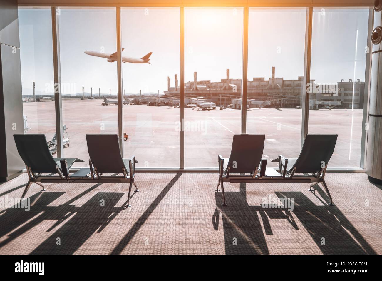 View from an airport terminal window showing chairs facing the runway ...