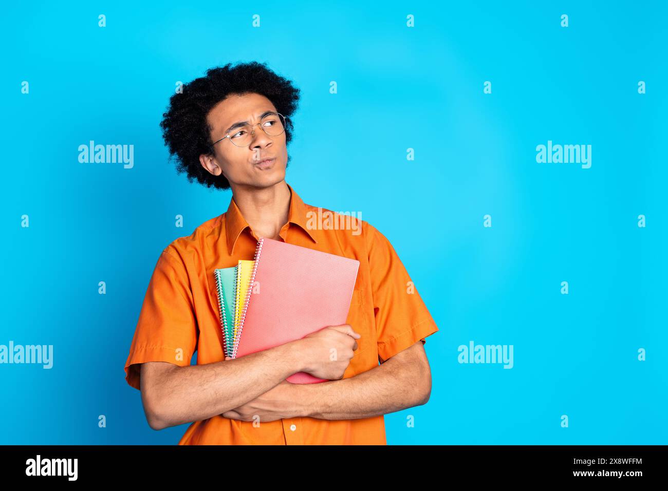 Photo of funky unsure guy dressed orange shirt eyeglasses reading ...
