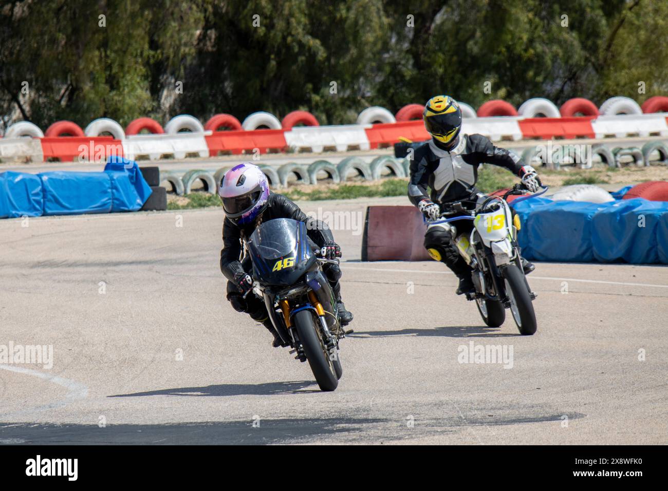 Female motorcycle racer with ponytails leading the race, navigating a ...
