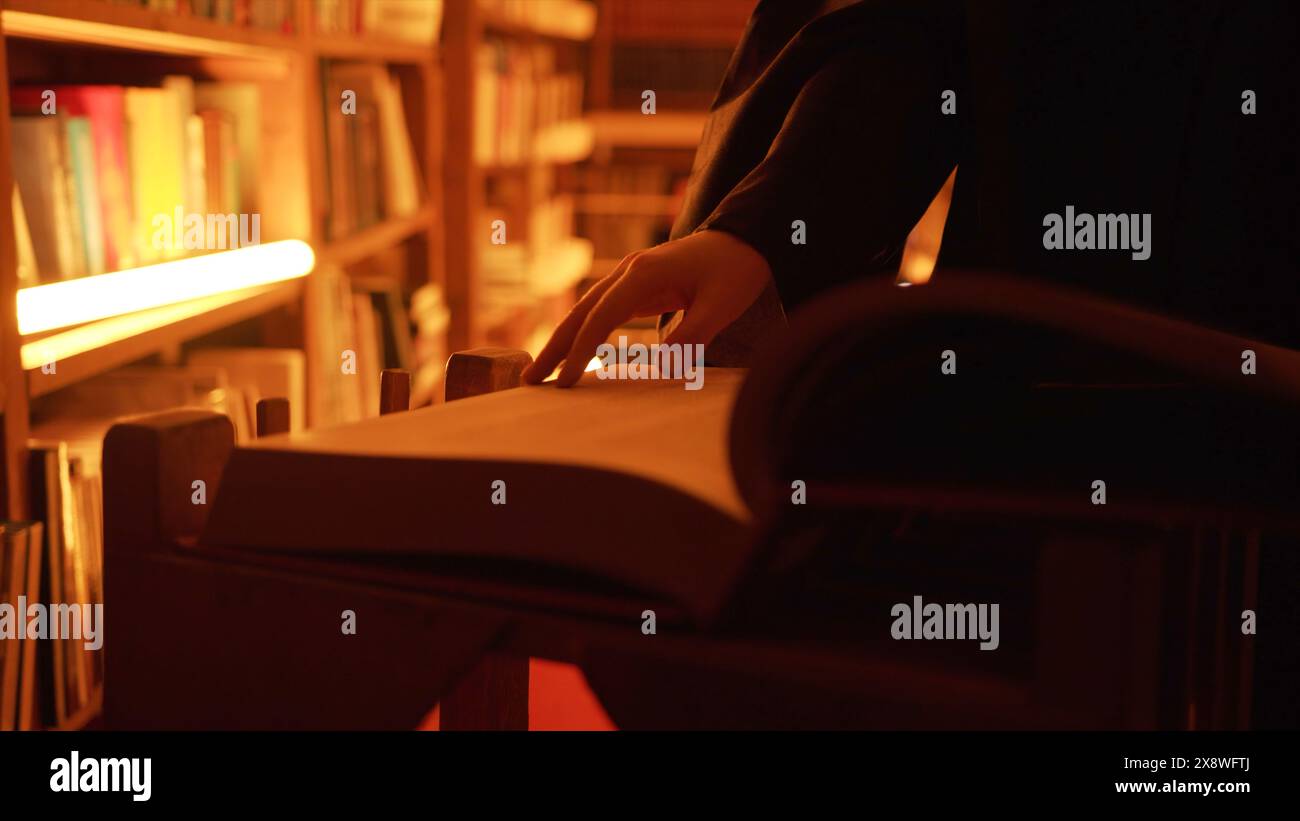Close-up of mysterious man opening large book. Stock footage. Man opens ...