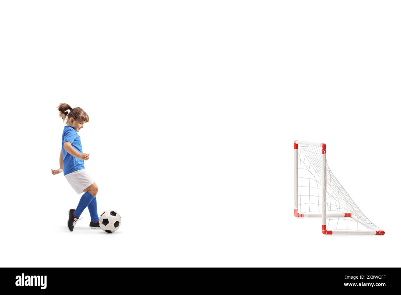 Girl running with a football towards a goal isolated on white ...