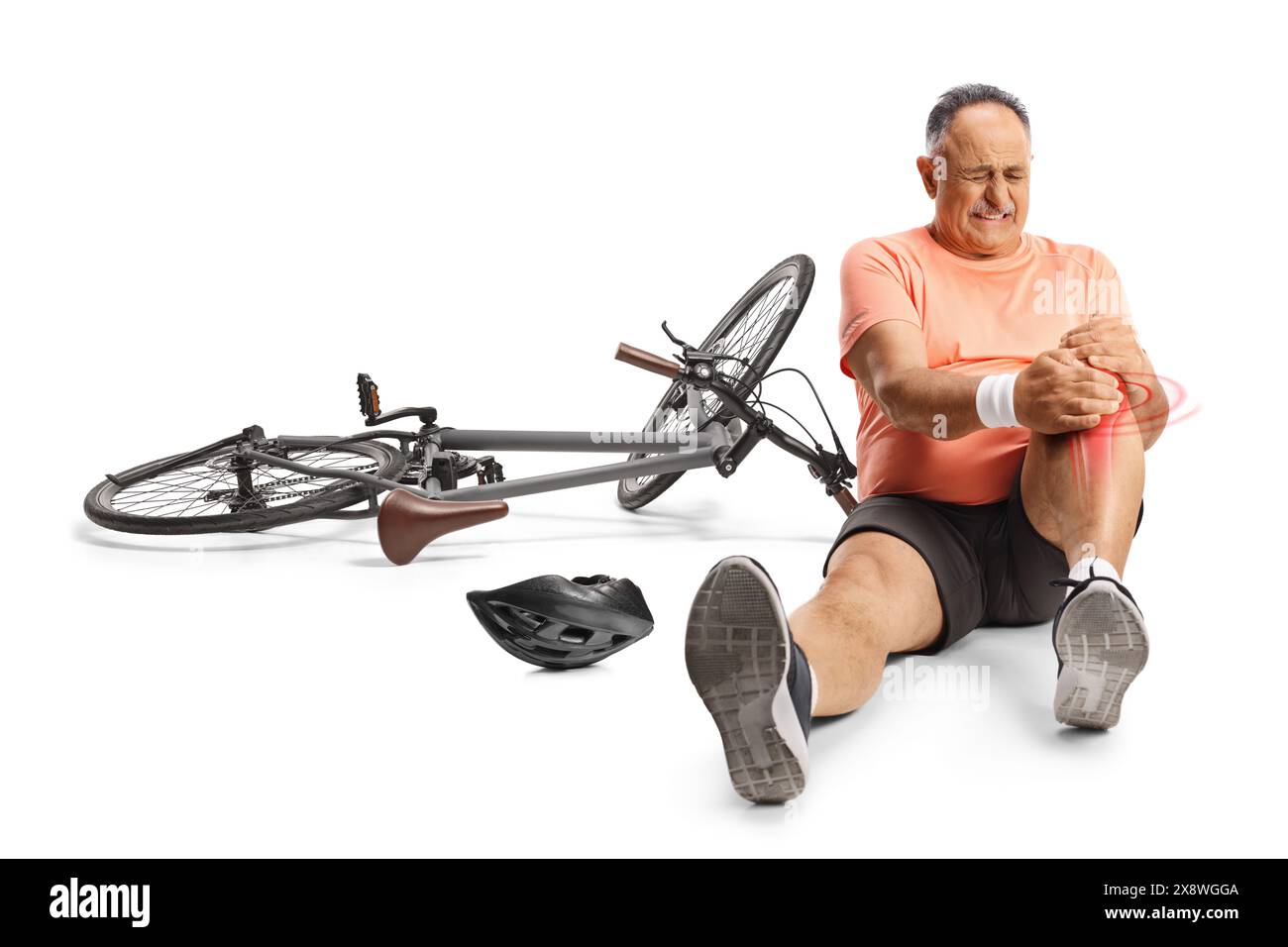Mature man falling from a bicycle, sitting on the ground and holding ...