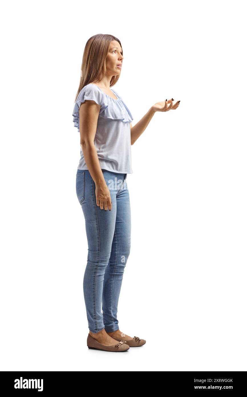 Young woman standing and gesturing with hand isolated on white ...