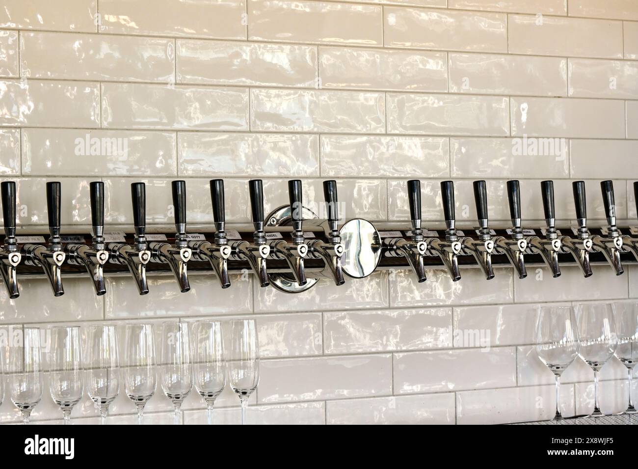 Row of taps in a wine bar for dispensing different types of wine by the ...