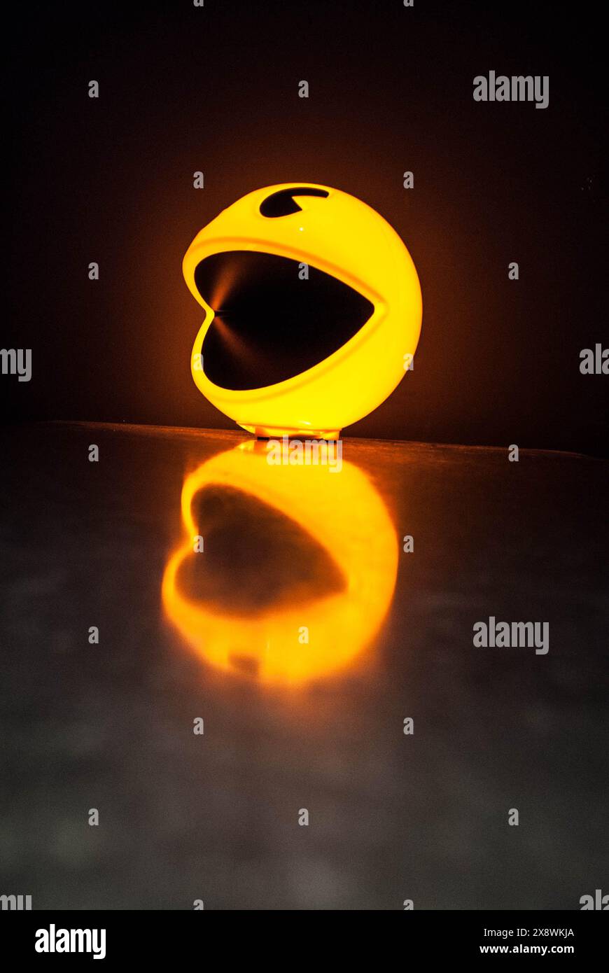 Bright yellow smiley face lamp emitting a warm glow, casting a ...