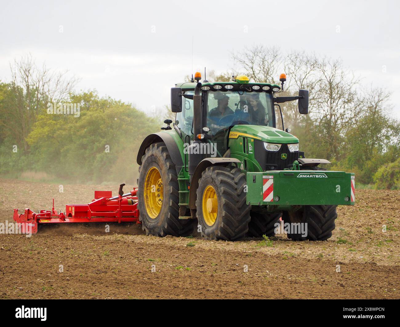 John Deere 6r215 power harrowing with a Kuhn HR 6003. Mount Bures, Essex, England UK Stock Photo ...