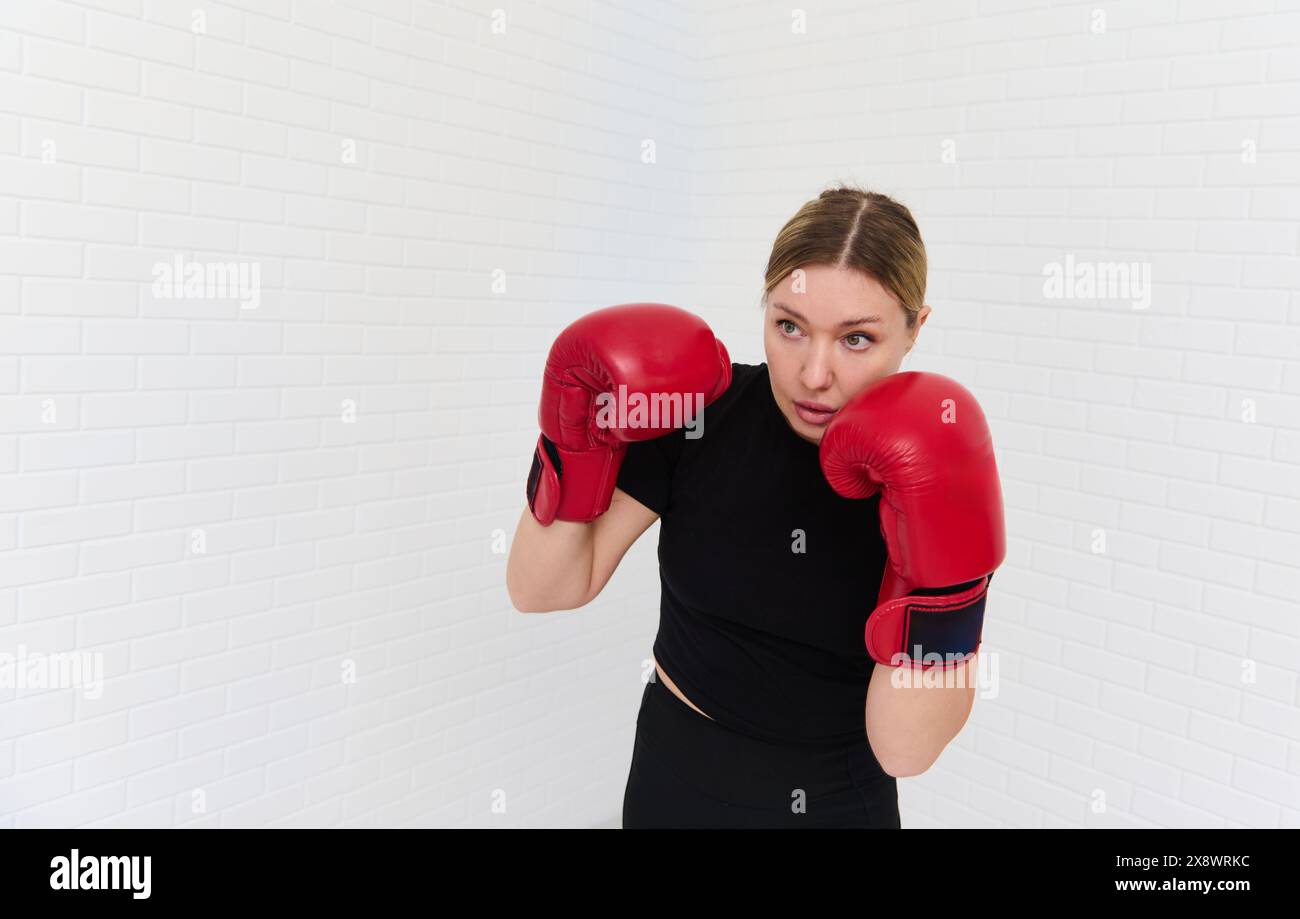 Confident determined young blond woman fighter, female boxer exercising ...