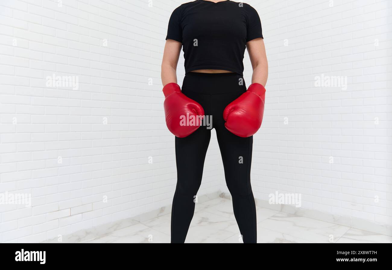 Authentic cropped portrait of a female boxer in black active wear with ...