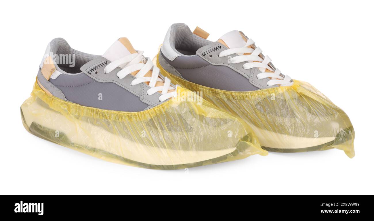 Men's sneakers in yellow shoe covers isolated on white Stock Photo - Alamy